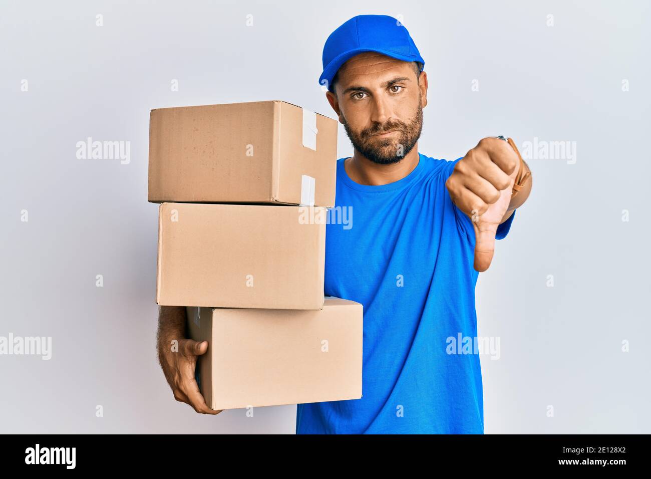 Handsome man with beard wearing courier uniform holding delivery ...