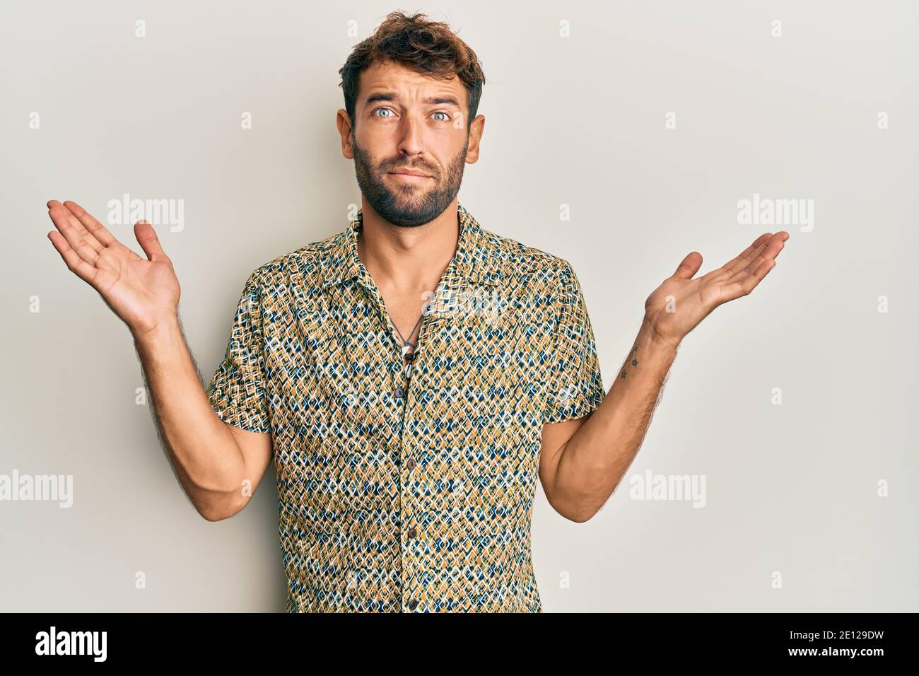 Handsome man with beard wearing casual fashion shirt clueless and ...