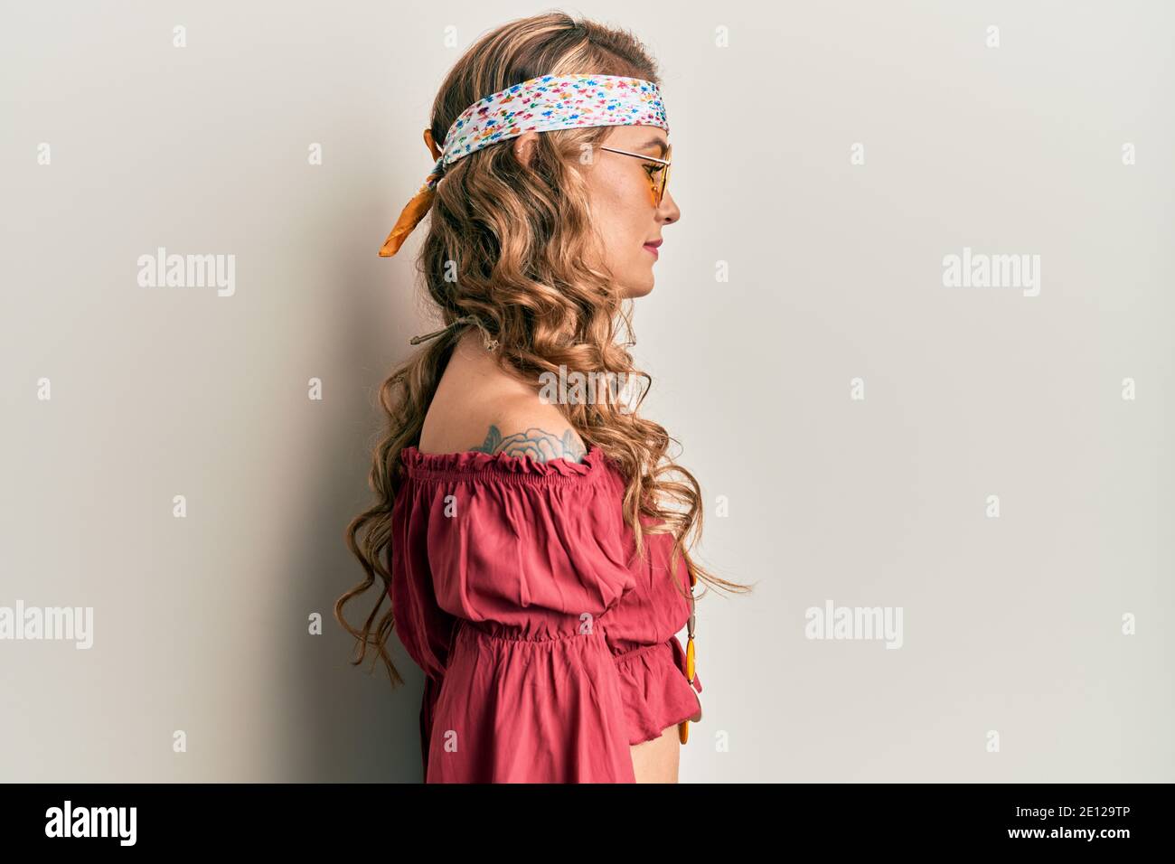 Young blonde girl wearing bohemian and hippie style looking to side ...