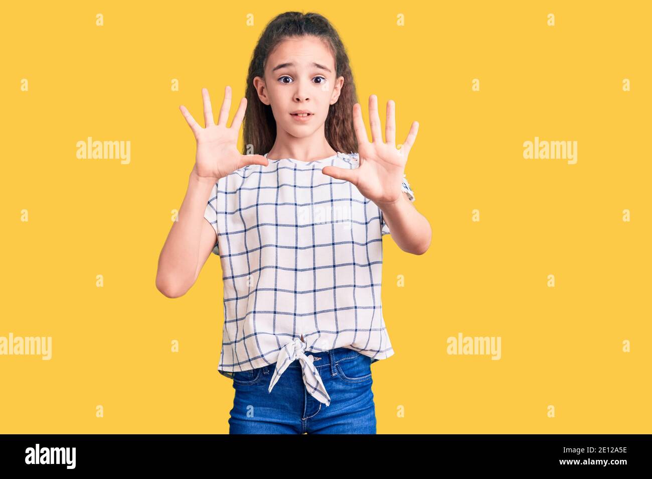 Cute hispanic child girl wearing casual clothes afraid and terrified ...