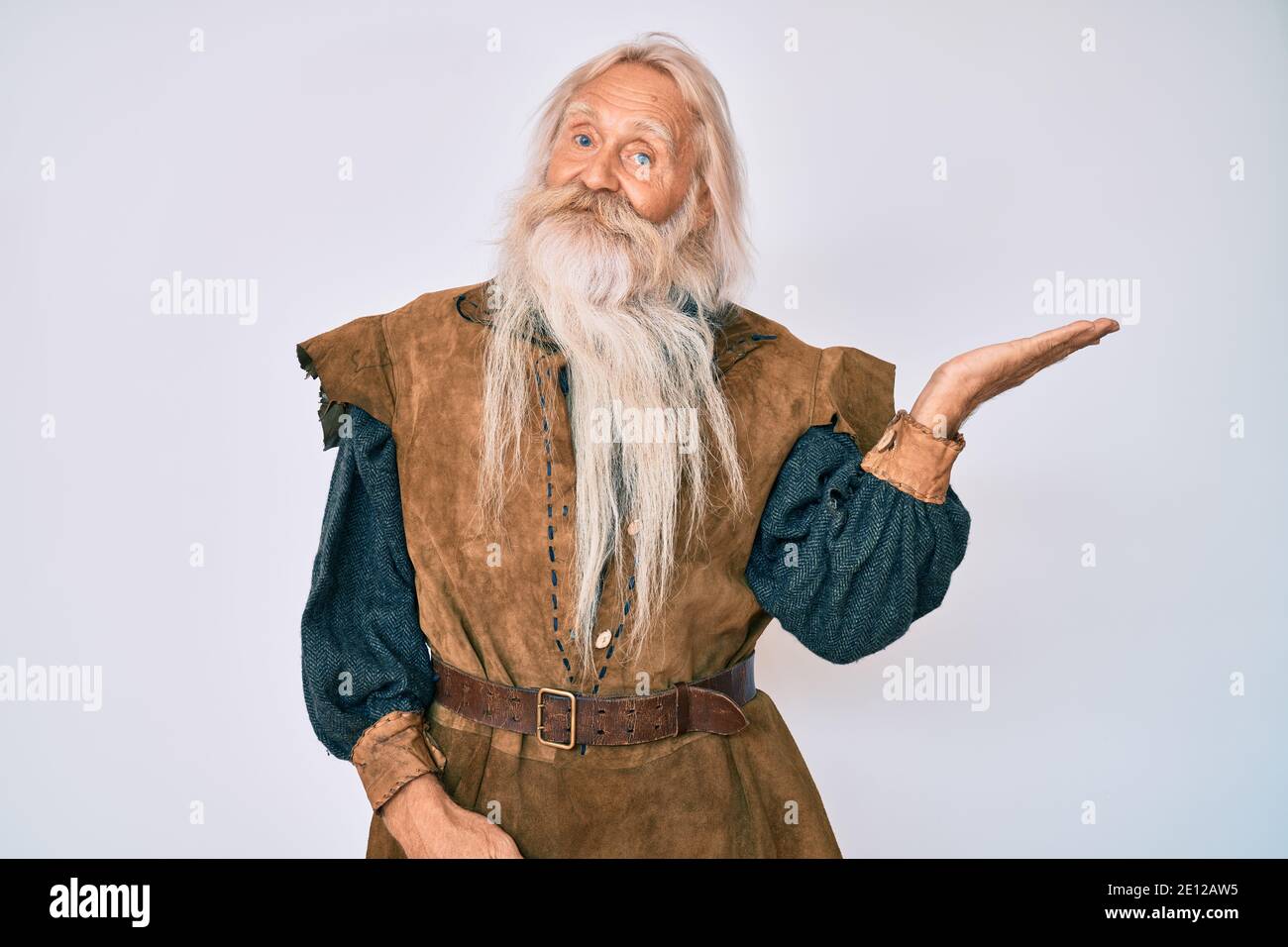 Old senior man with grey hair and long beard wearing viking traditional ...
