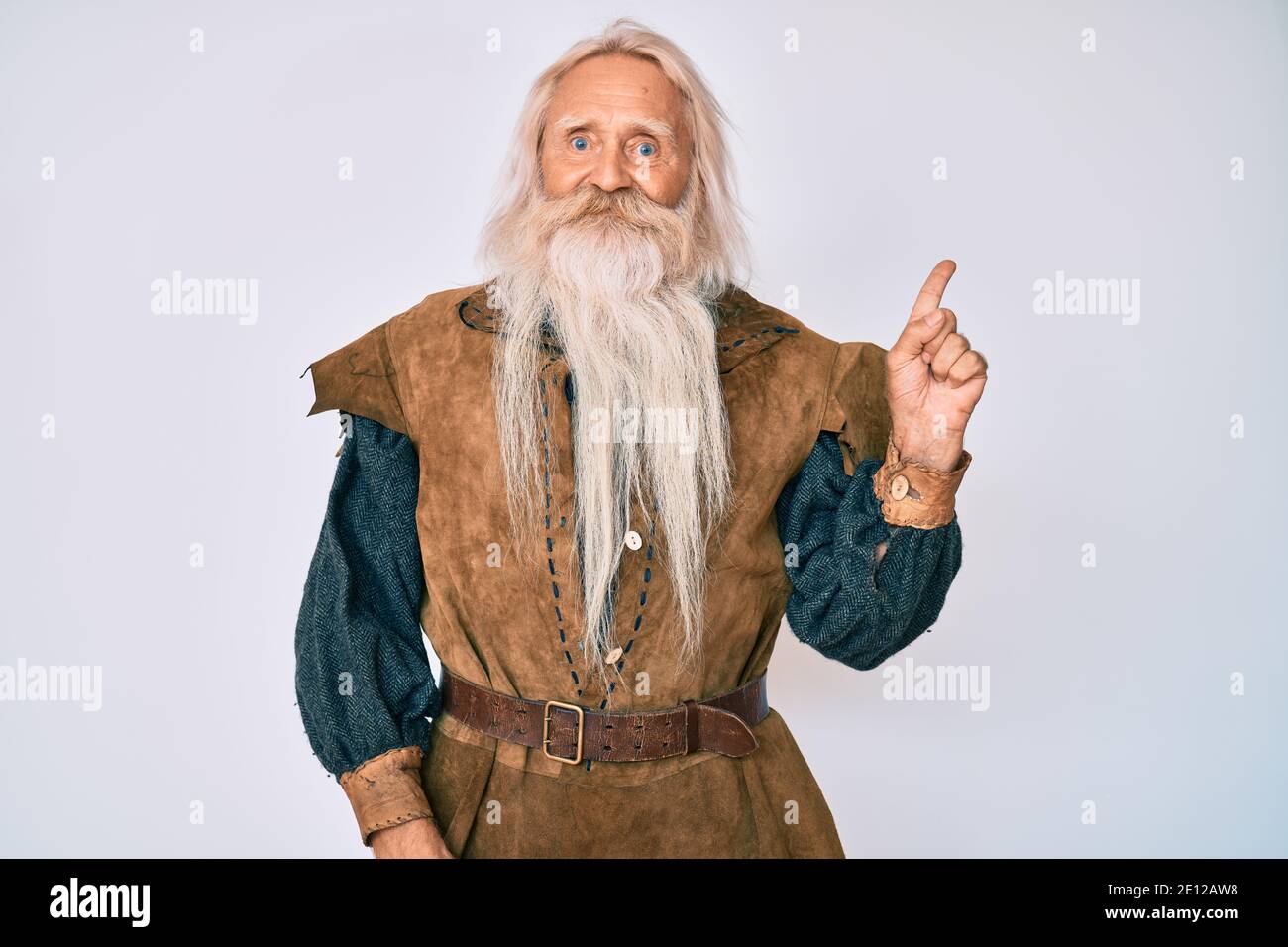 Old senior man with grey hair and long beard wearing viking traditional ...