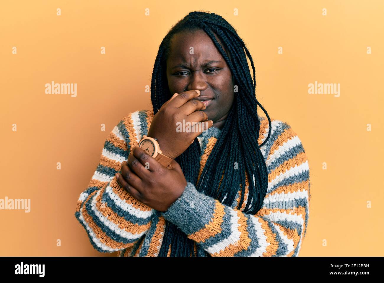 Young black woman with braids wearing casual winter sweater suffering ...