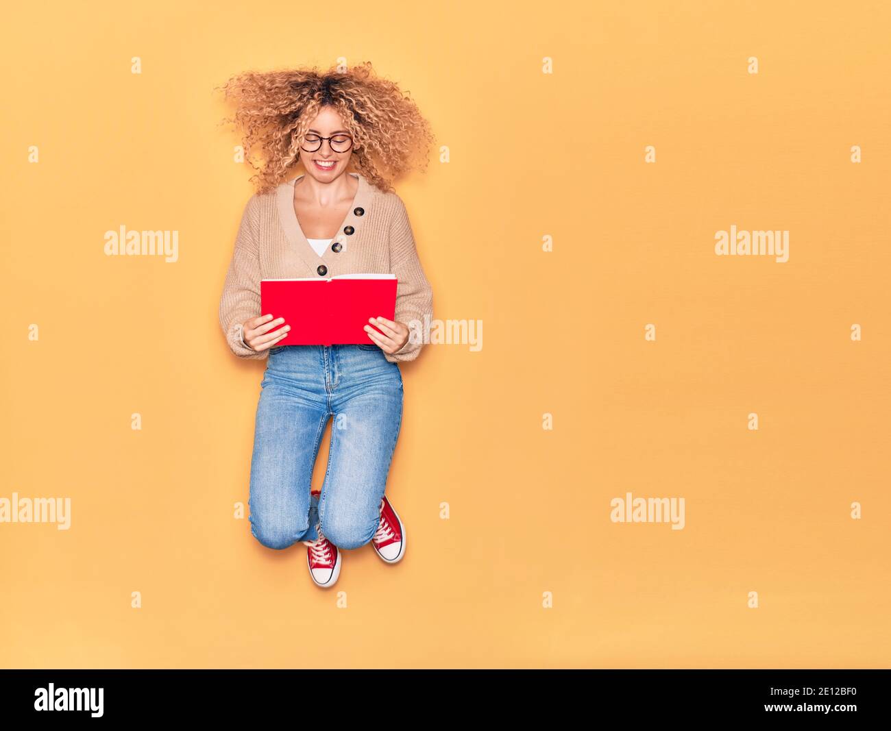 Young beautiful curly student girl wearing glasses smiling happy ...