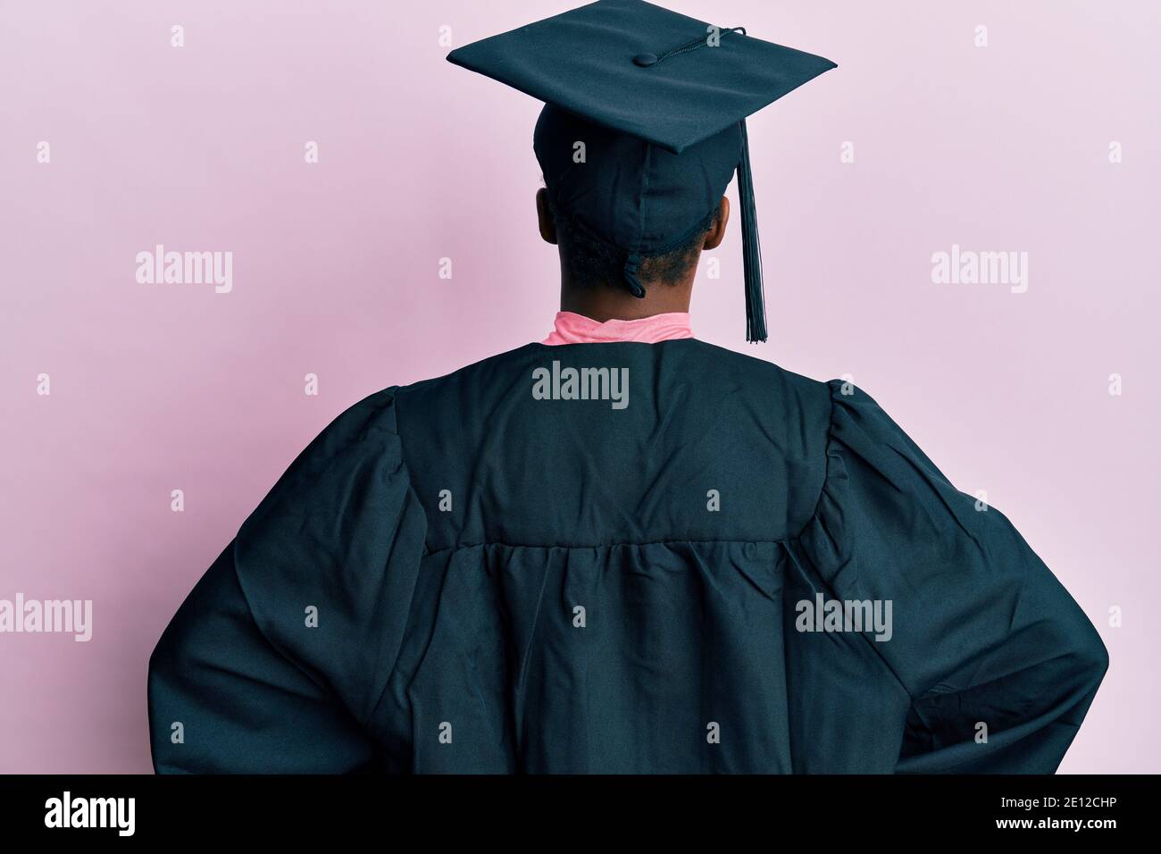 Young african american girl wearing graduation cap and ceremony robe ...