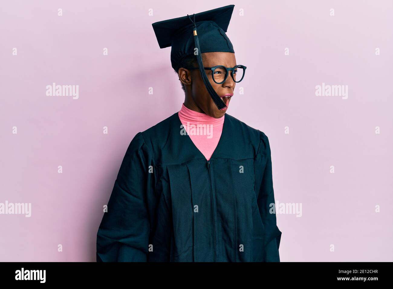 Young african american girl wearing graduation cap and ceremony robe ...