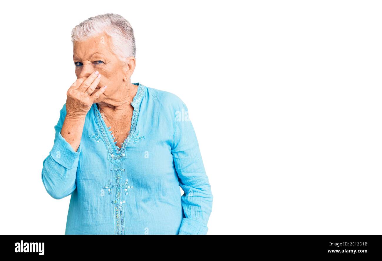 Senior beautiful woman with blue eyes and grey hair wearing summer ...