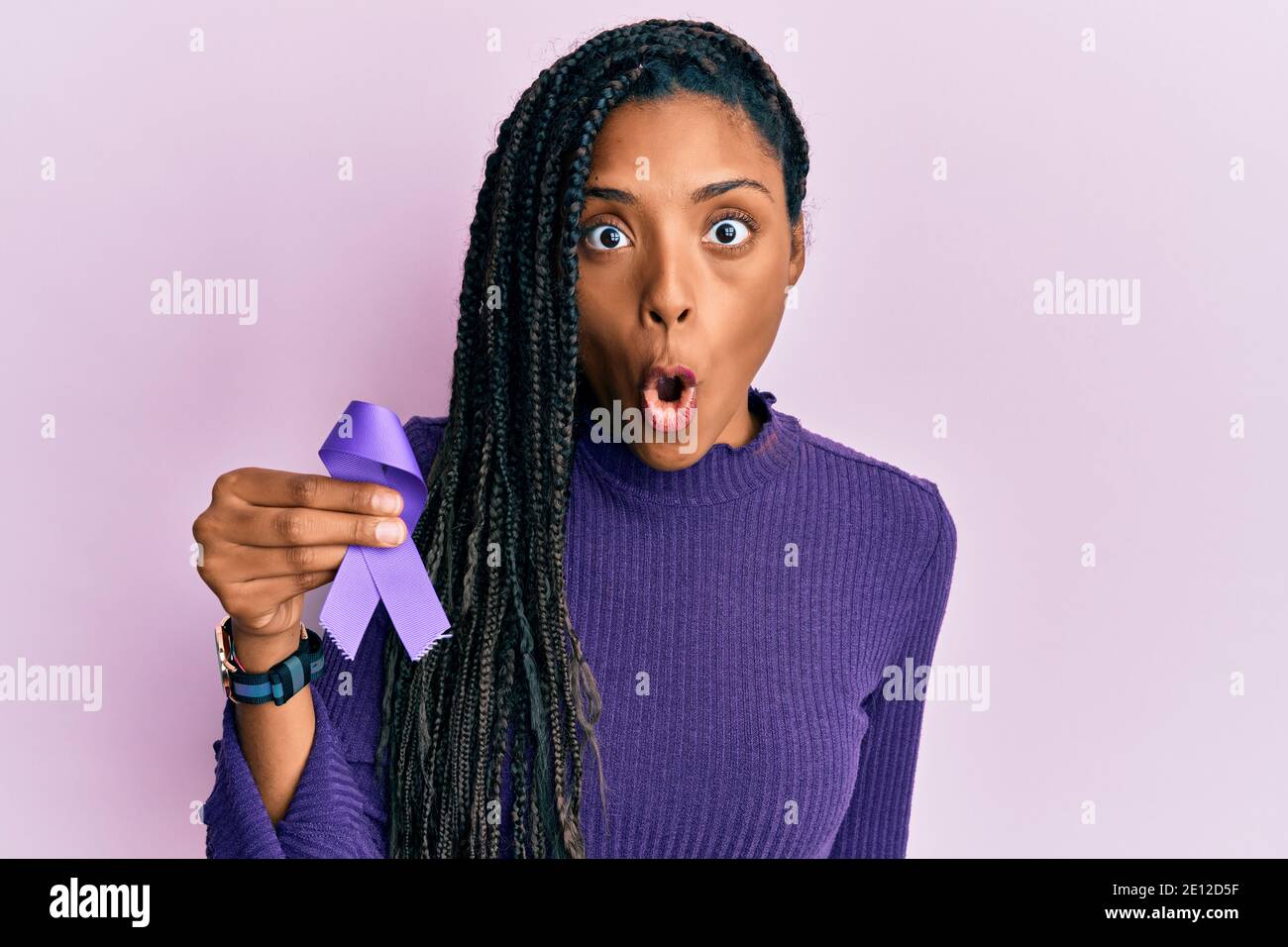 African american woman holding purple ribbon awareness scared and ...
