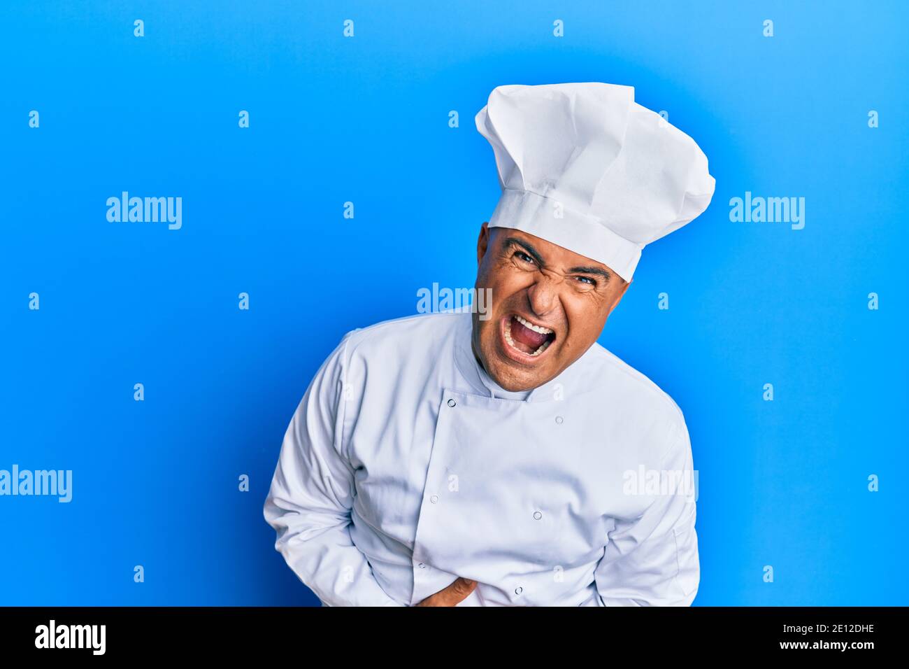 Mature middle east man wearing professional cook uniform and hat with ...