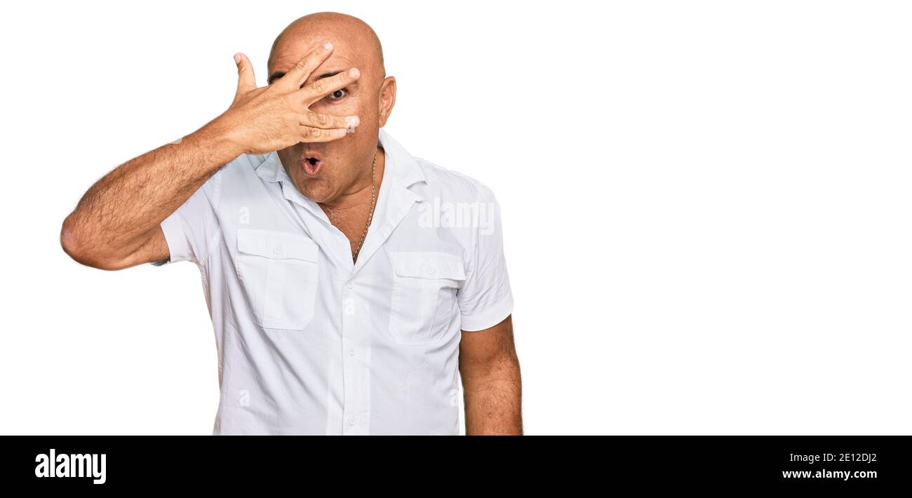 Mature middle east man with mustache wearing casual white shirt peeking ...