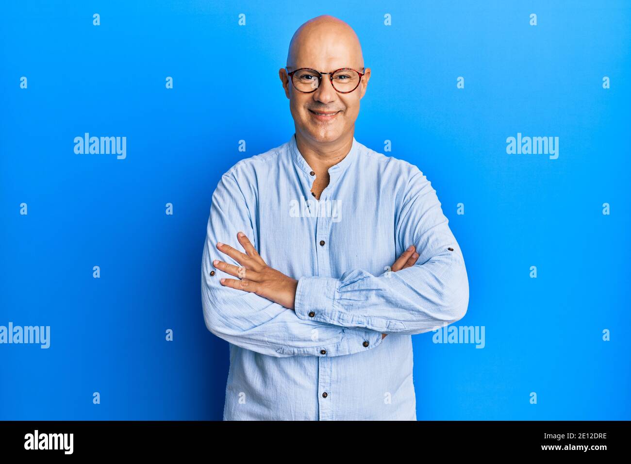 Middle age bald man wearing casual clothes and glasses happy face ...