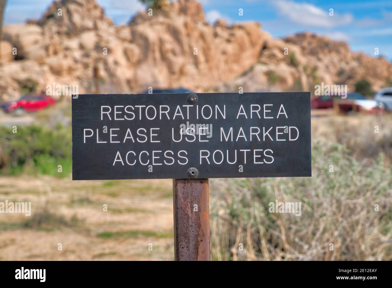 Restoration Area sign agaisnt desert landscape at Joshua Tree National ...
