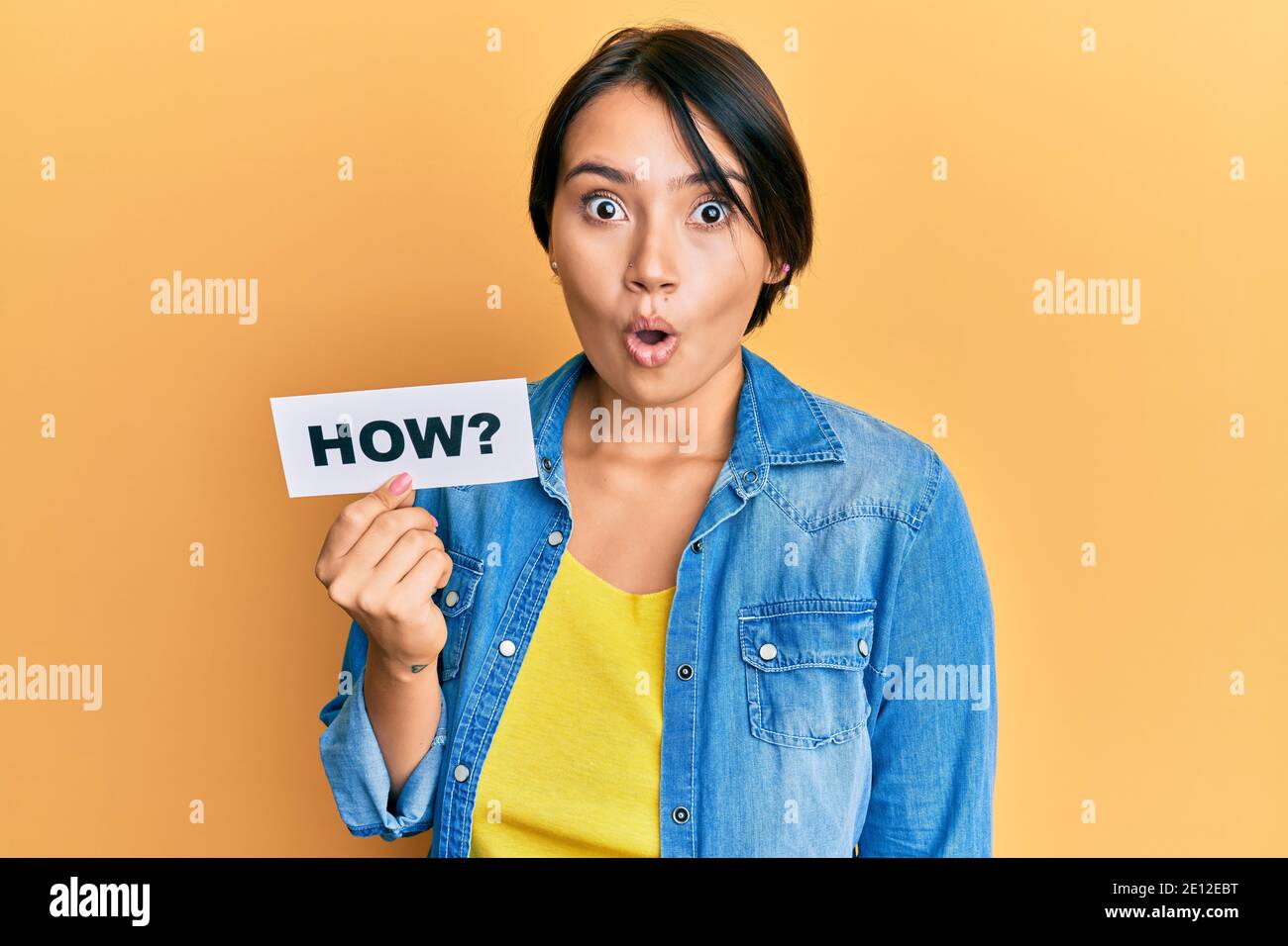 Beautiful young woman with short hair holding paper with how message ...