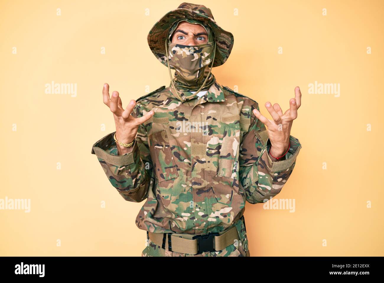 Young handsome man wearing camouflage army uniform and balaclava crazy ...