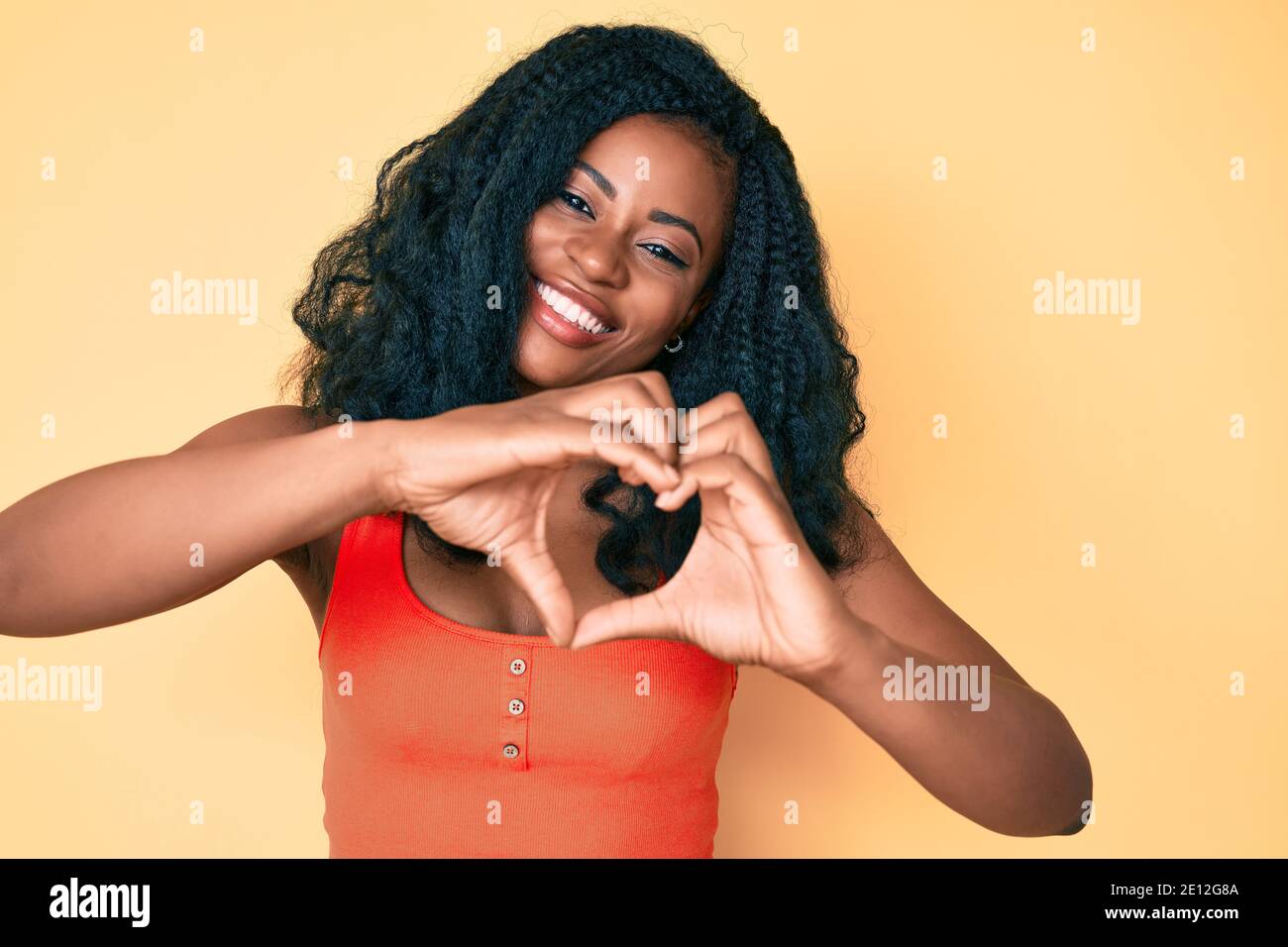 Beautiful african woman wearing casual clothes smiling in love doing ...