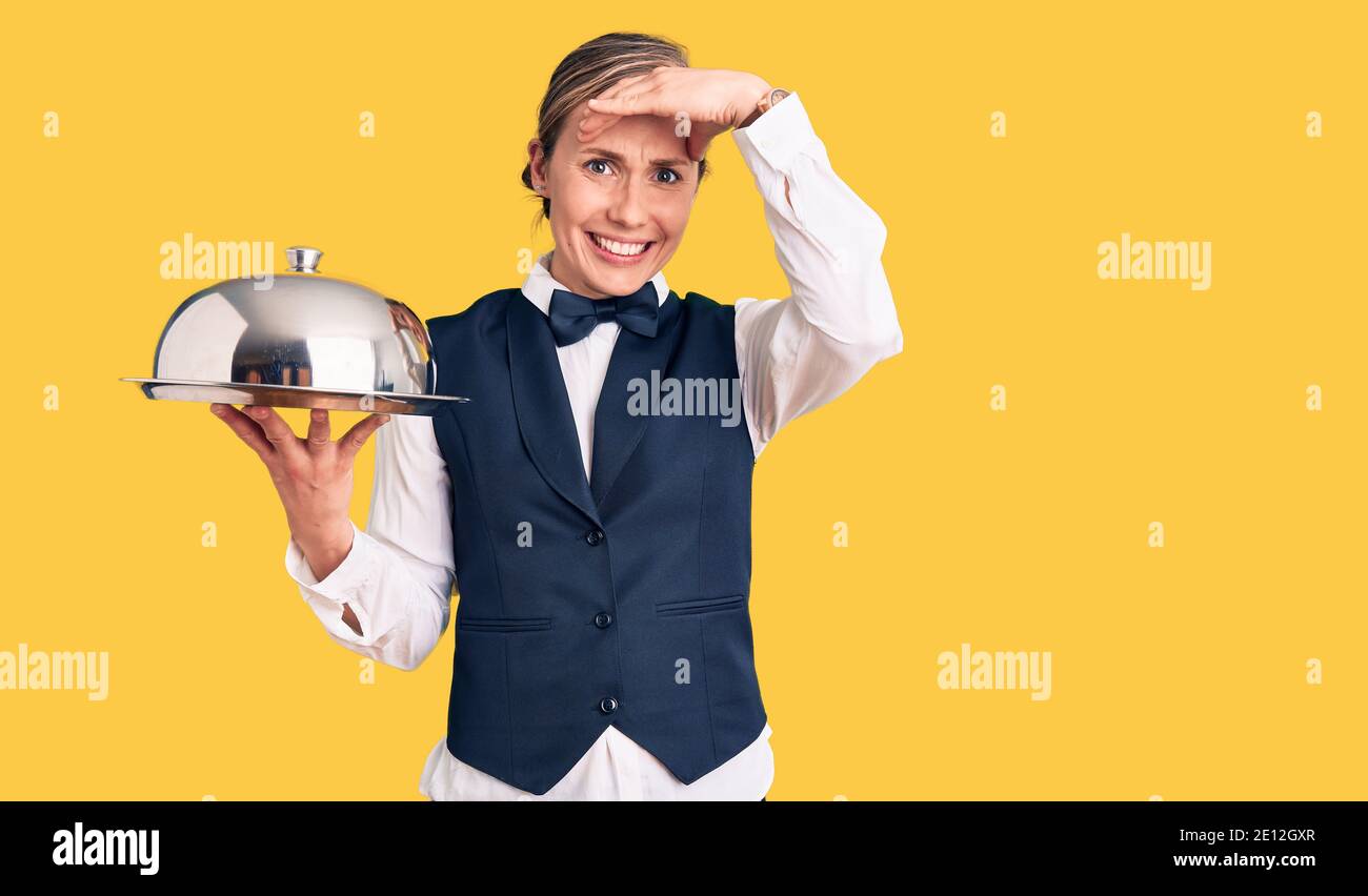 Young beautiful blonde woman wearing waitress uniform holding tray ...