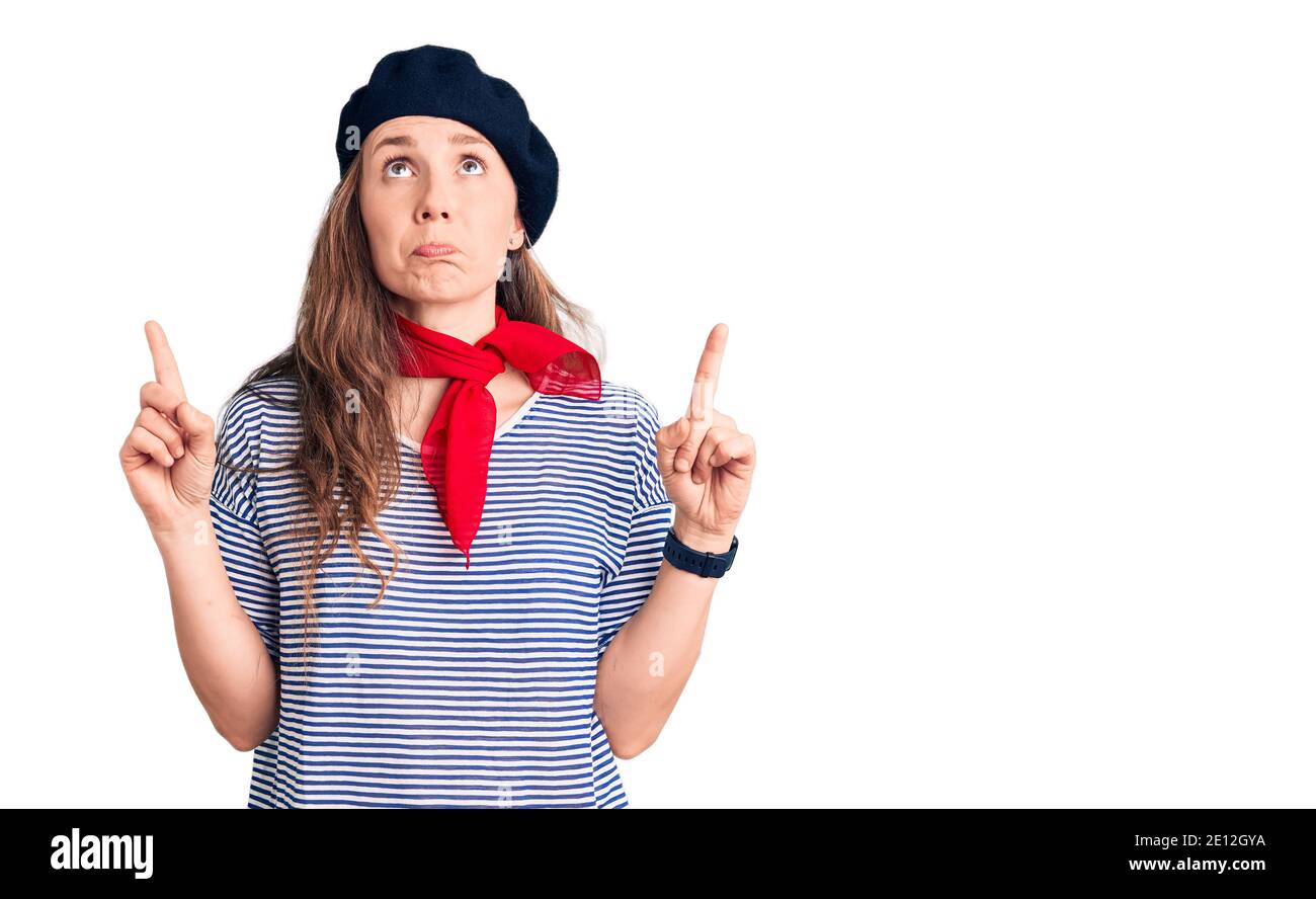 Young beautiful blonde woman wearing french beret and striped t-shirt ...