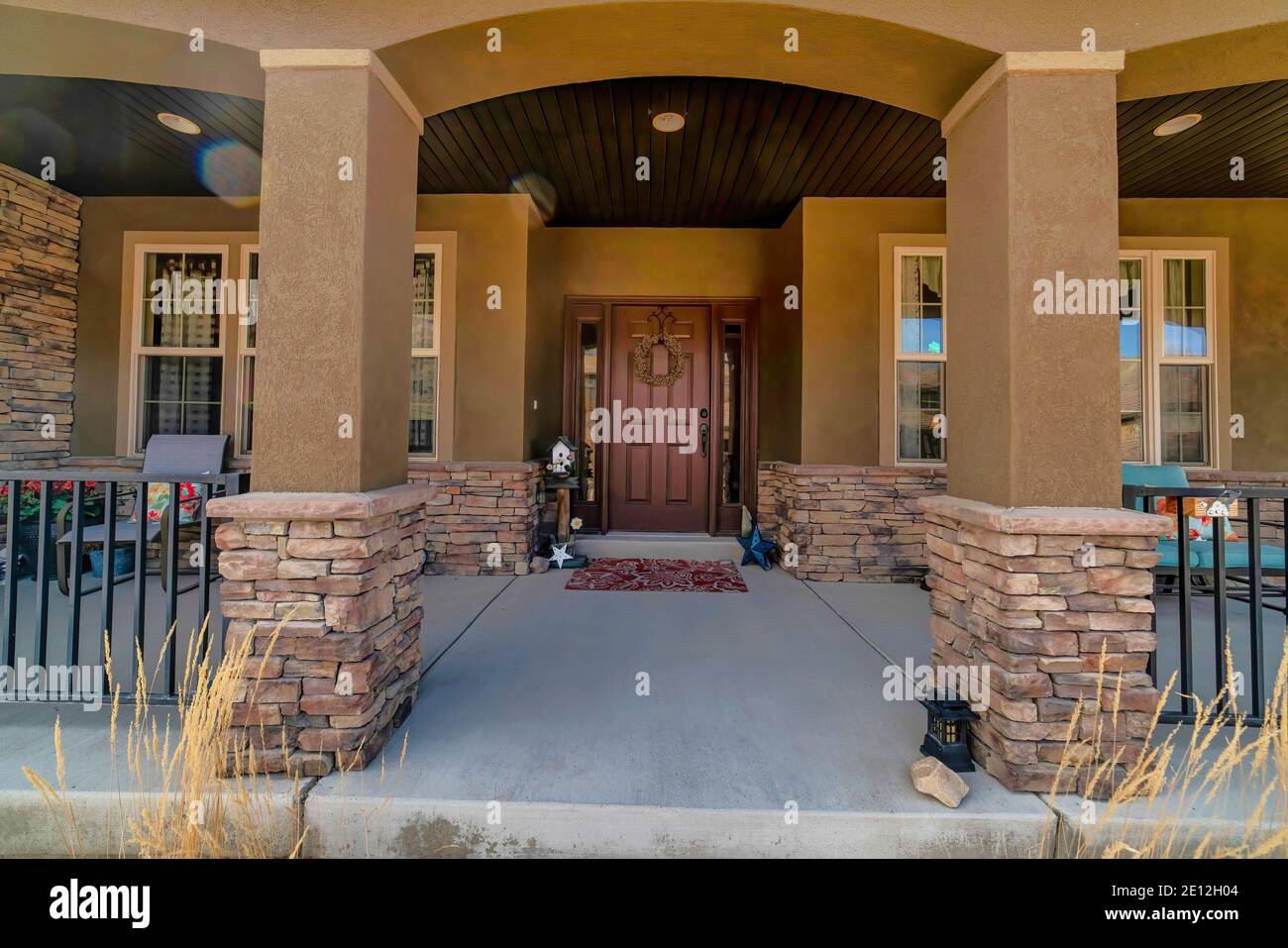 Front view of home with arch porch columns at the entrance and brown ...