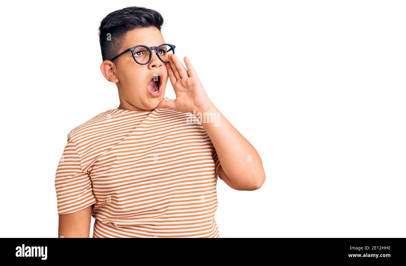 Little boy kid wearing casual clothes and glasses shouting and ...