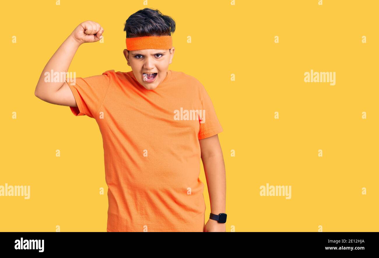 Little boy kid wearing sportswear angry and mad raising fist frustrated ...