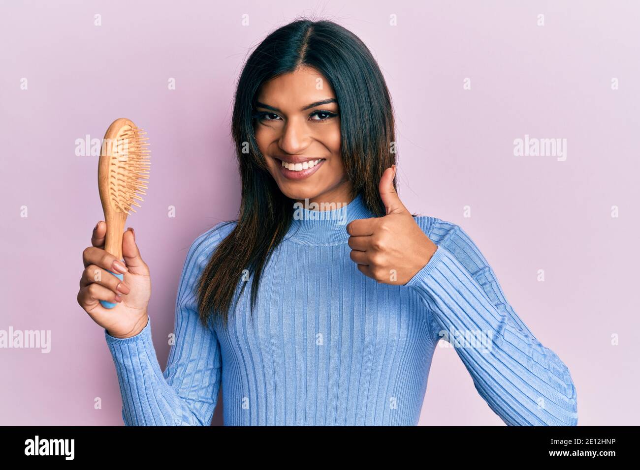 Young latin transsexual transgender woman holding hairbrush smiling ...