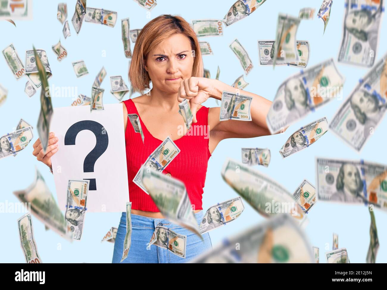 Young blonde woman holding question mark with angry face, negative sign ...