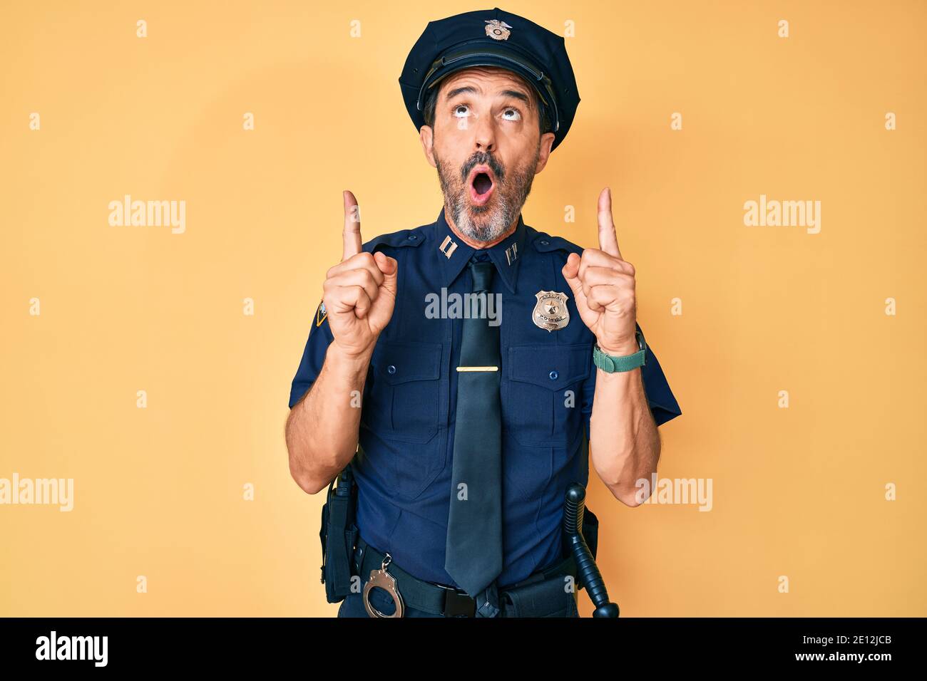 Middle age hispanic man wearing police uniform amazed and surprised ...