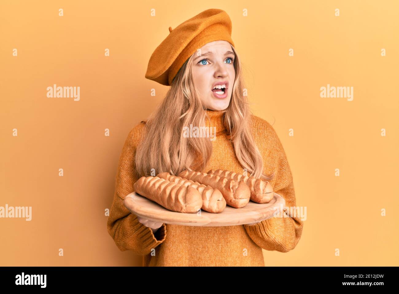 Beautiful young caucasian girl wearing french look with beret holding ...