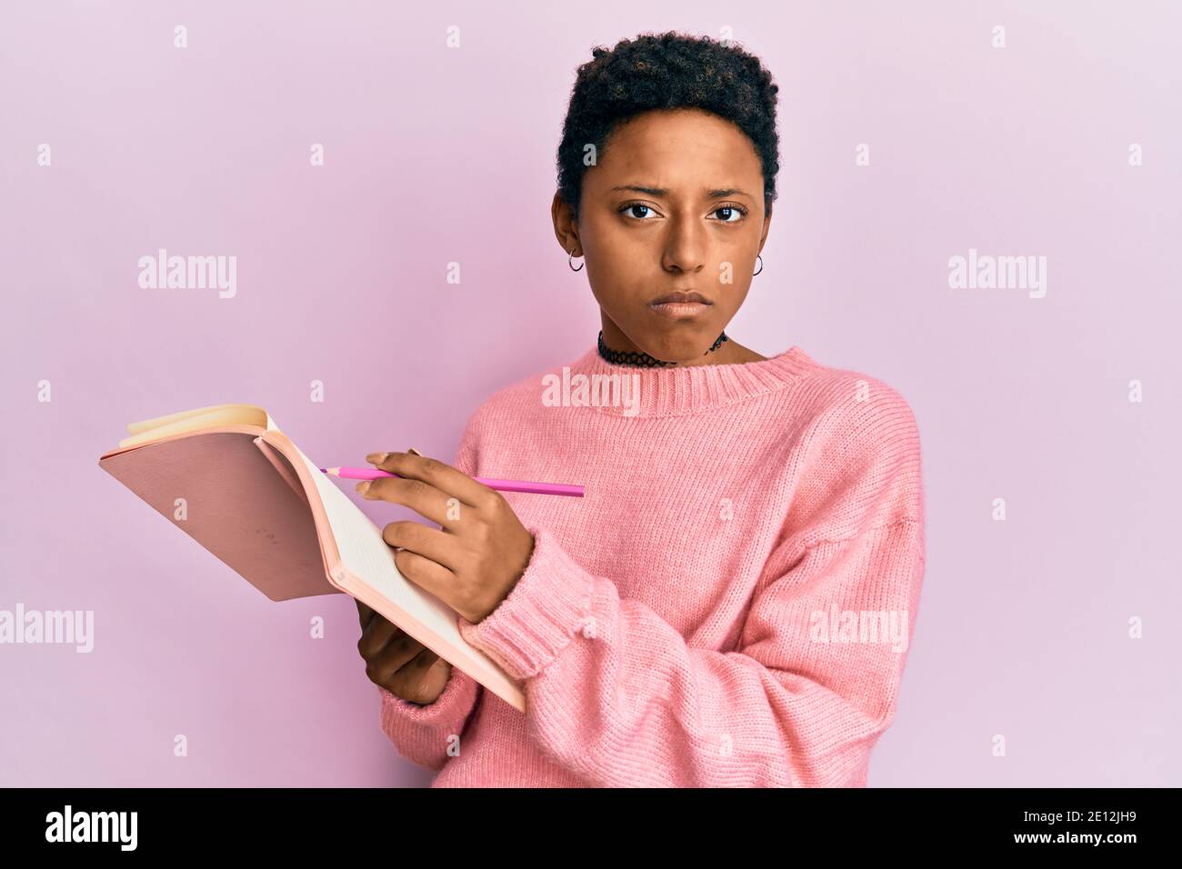 Young african american girl reading and writing book depressed and ...