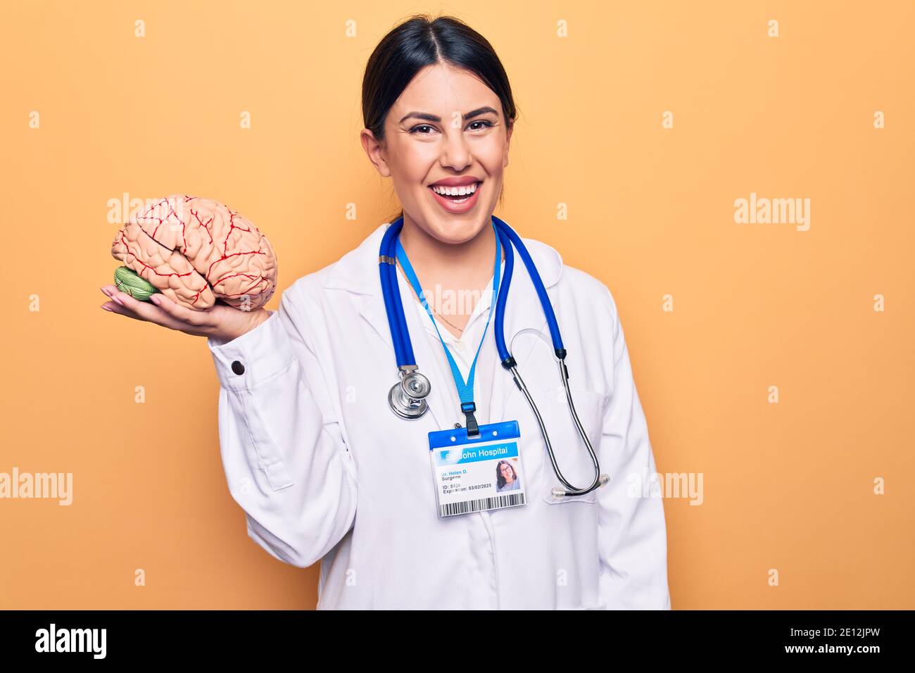 Young beautiful psychiatrist woman wearing stethoscope holding brain ...