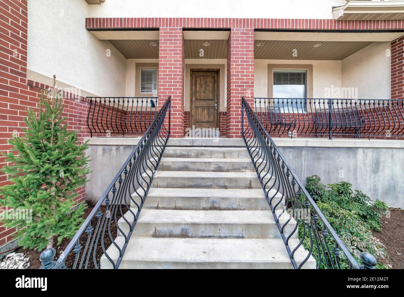 Front view of home with stairs going up to the elevated porch and brown ...