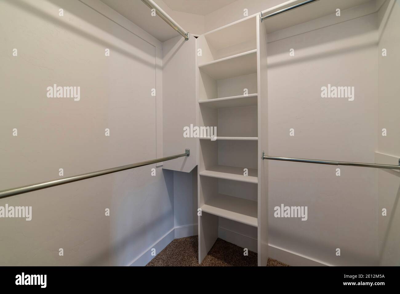 Empty closet with built in multi layer open shelves and clothes rod ...