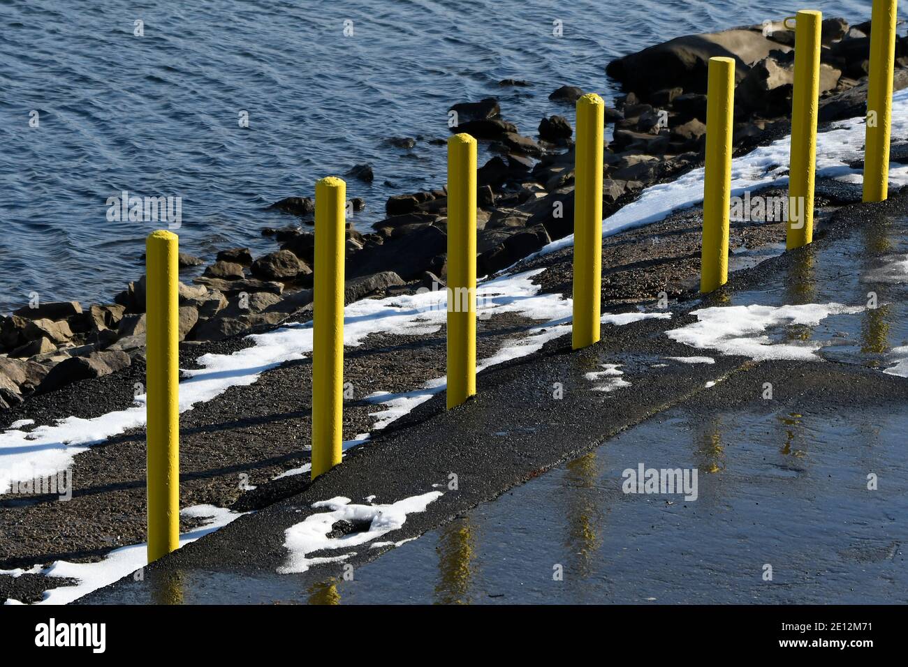 yellow concrete post near boat loading dock reflecting from rain water ...
