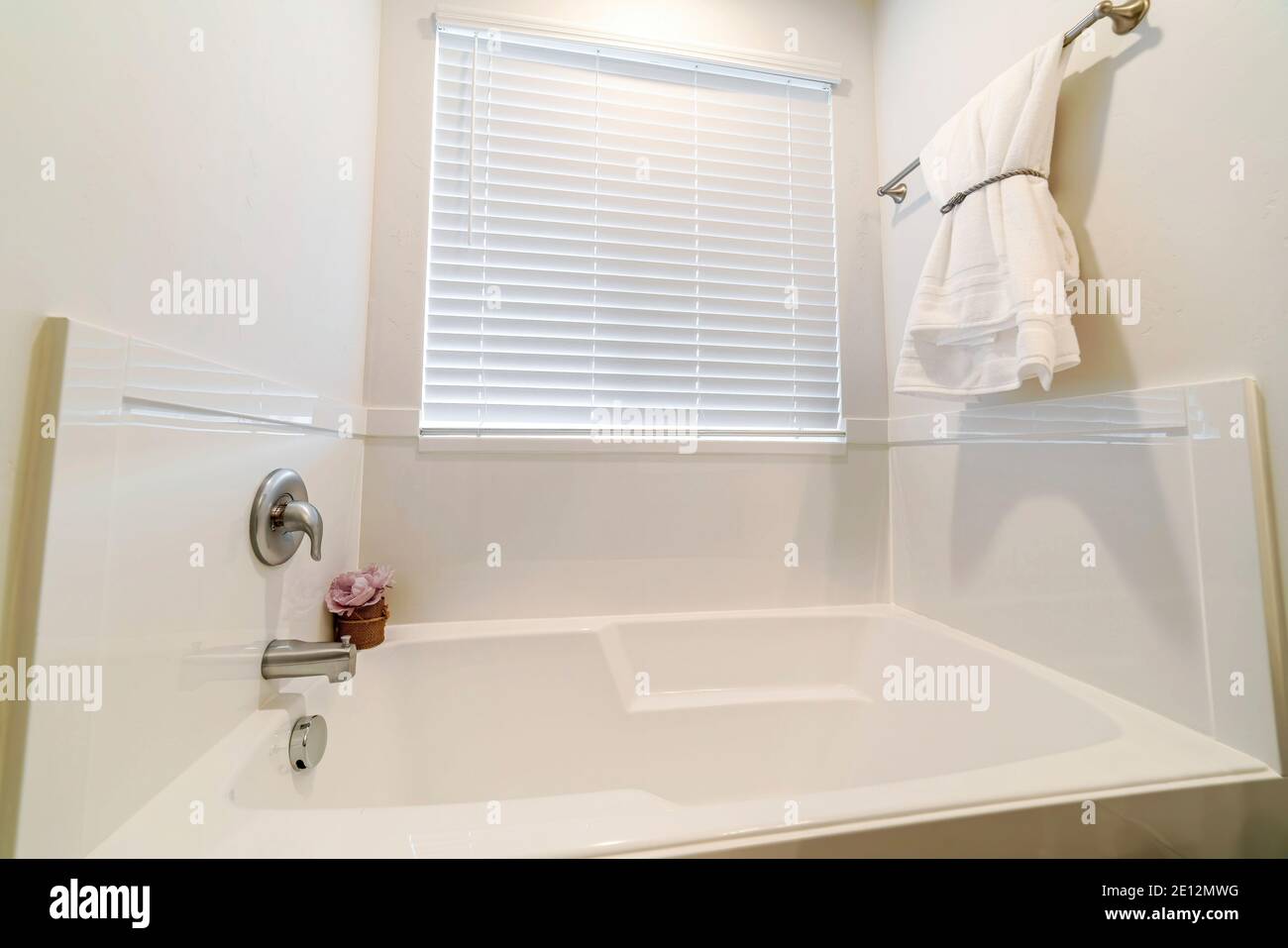 Built in shiny bathtub inside clean bathroom of home with white ...