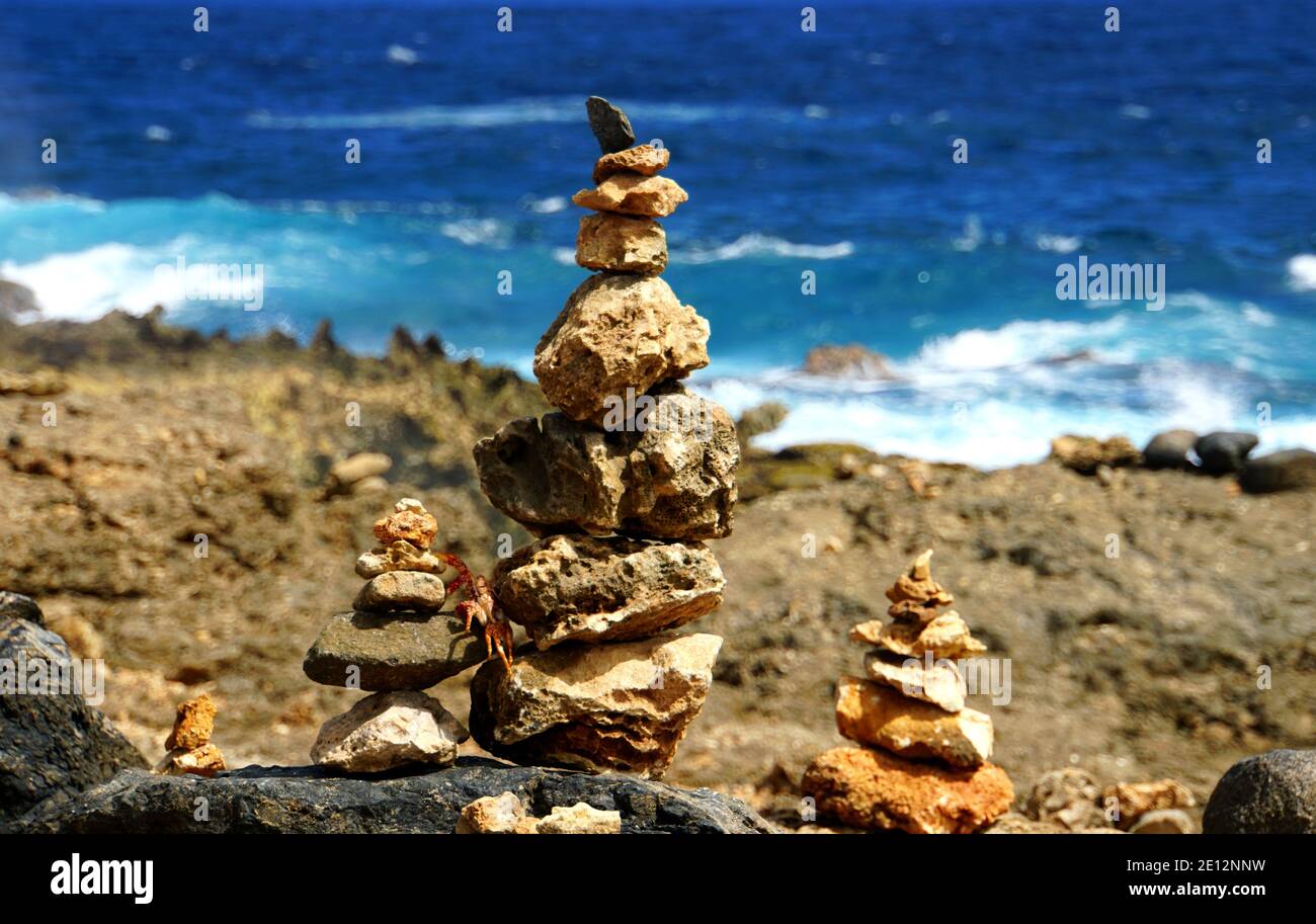 Multiple sizes of balancing rocks along the ocean in Aruba Stock Photo ...