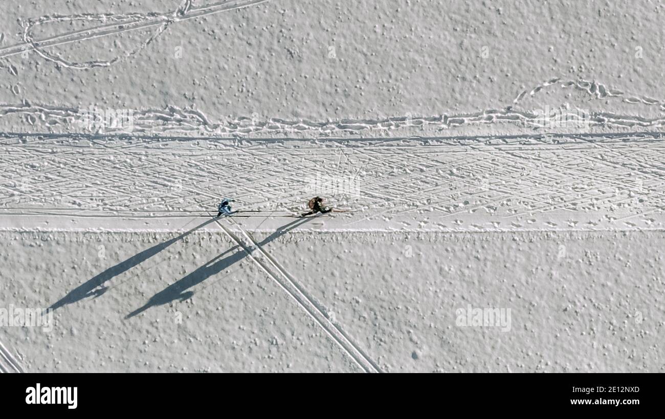 Skiing couple straight from above filmed by a drone at a winter track ...