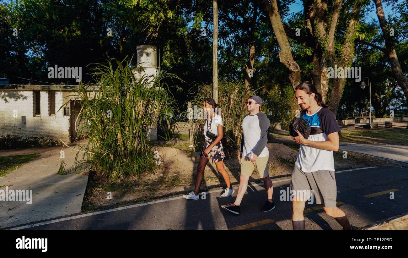 three friends laughing while walking along a path Stock Photo - Alamy