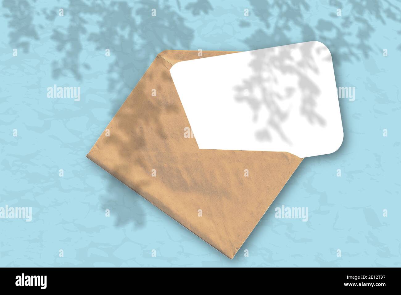 An envelope with a sheet of white textured paper on the blue background ...