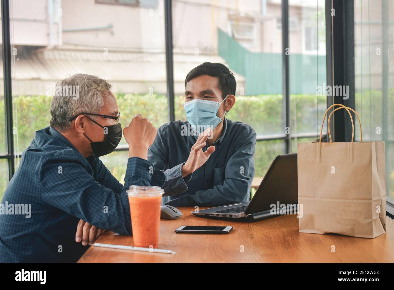Asian man two people talking in office and working by computer notebook ...