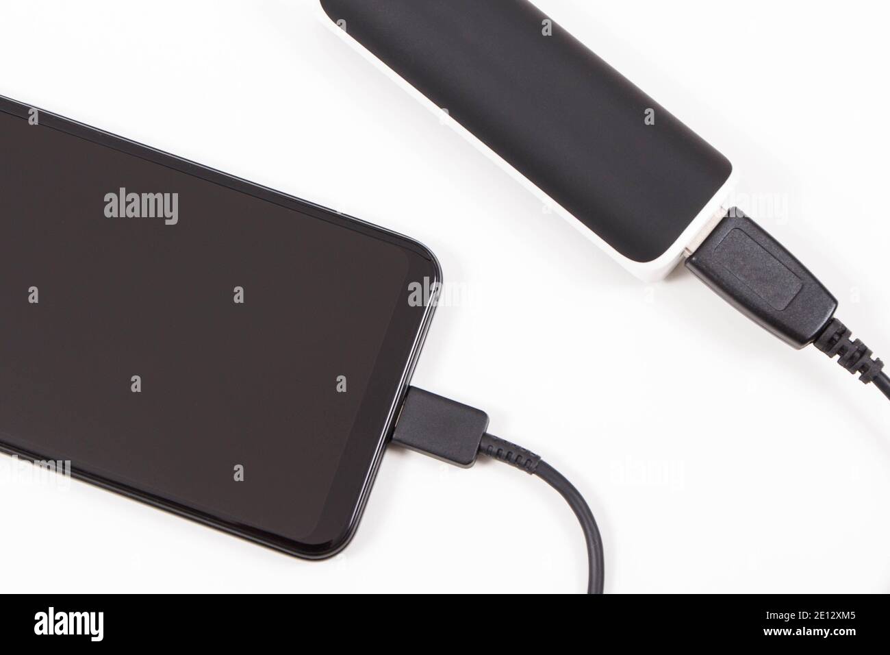 Smartphone with connected plug of powerbank. Telephone charging. White ...
