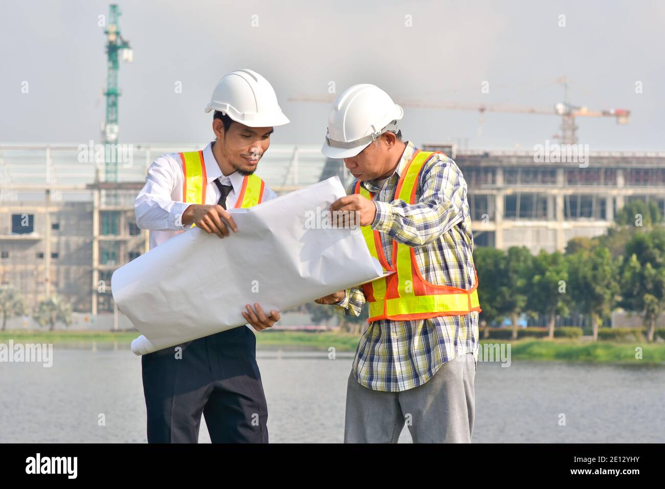 Two Engineer holding blueprint talking discussion building project real ...
