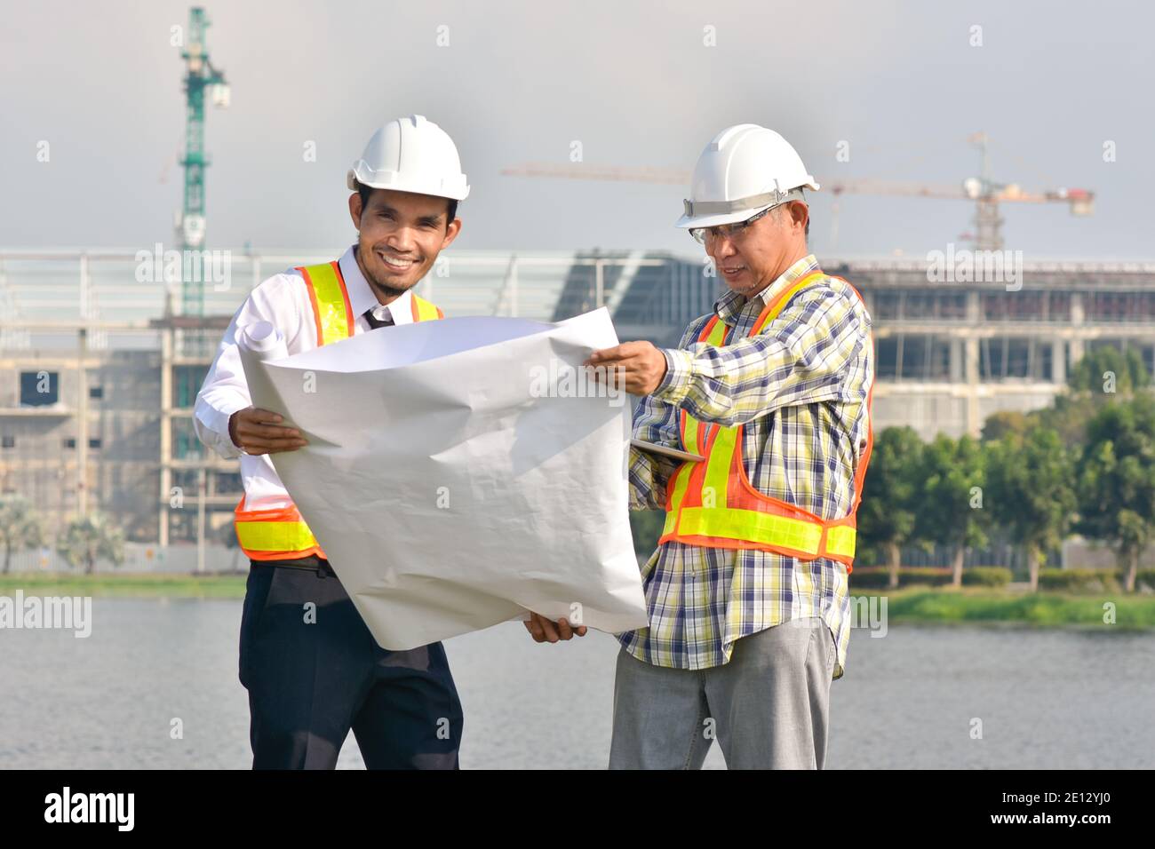 Two Engineer holding blueprint talking discussion building project real ...