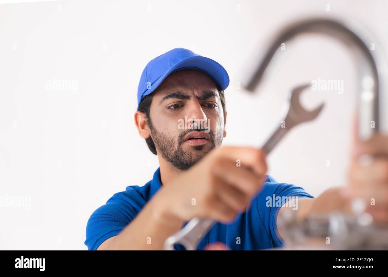 A PLUMBER LOOKING CONFUSED WHILE FIXING A BROKEN TAP Stock Photo - Alamy