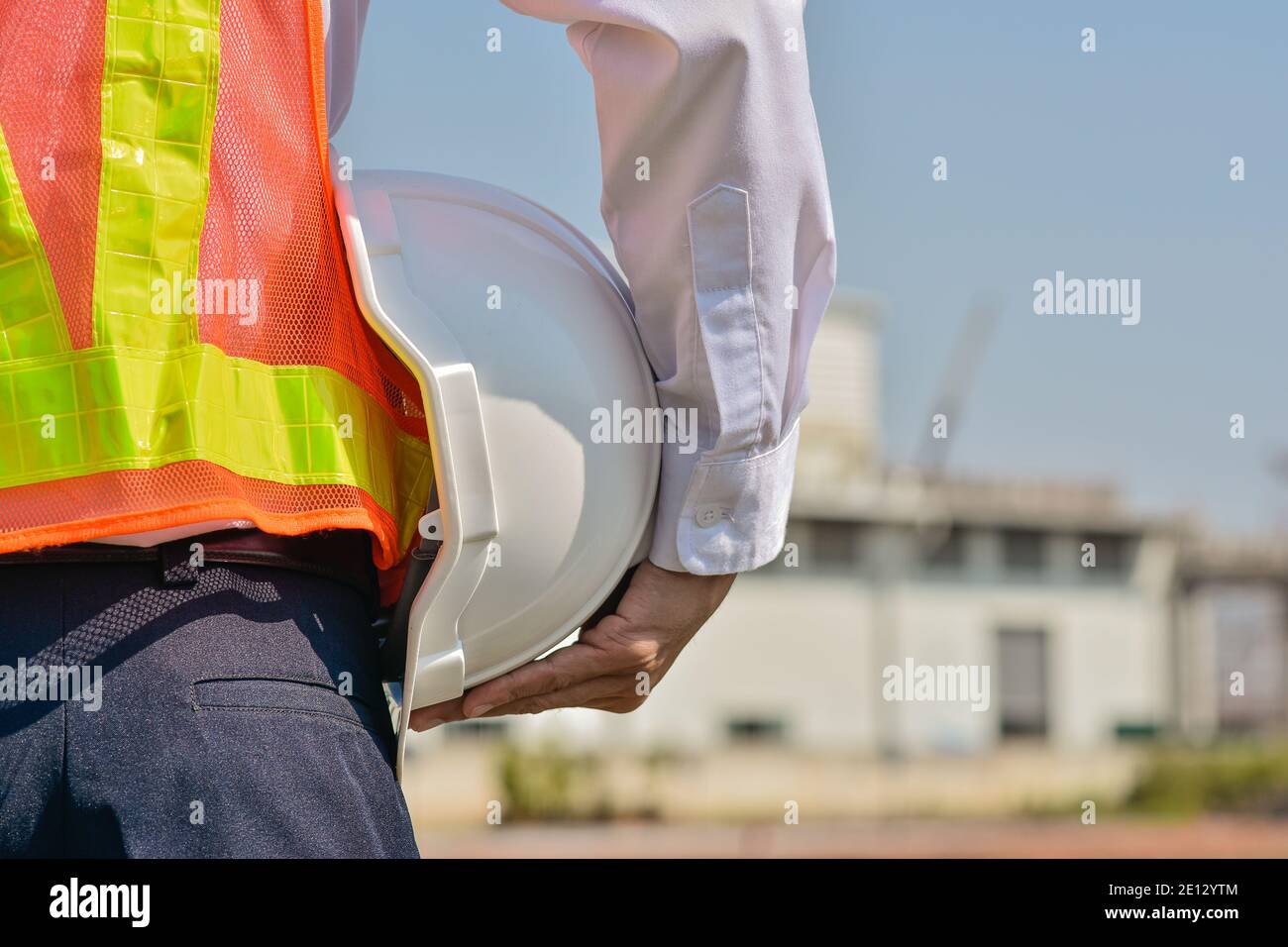 Professional Engineer holding white hard hat on site construction ...