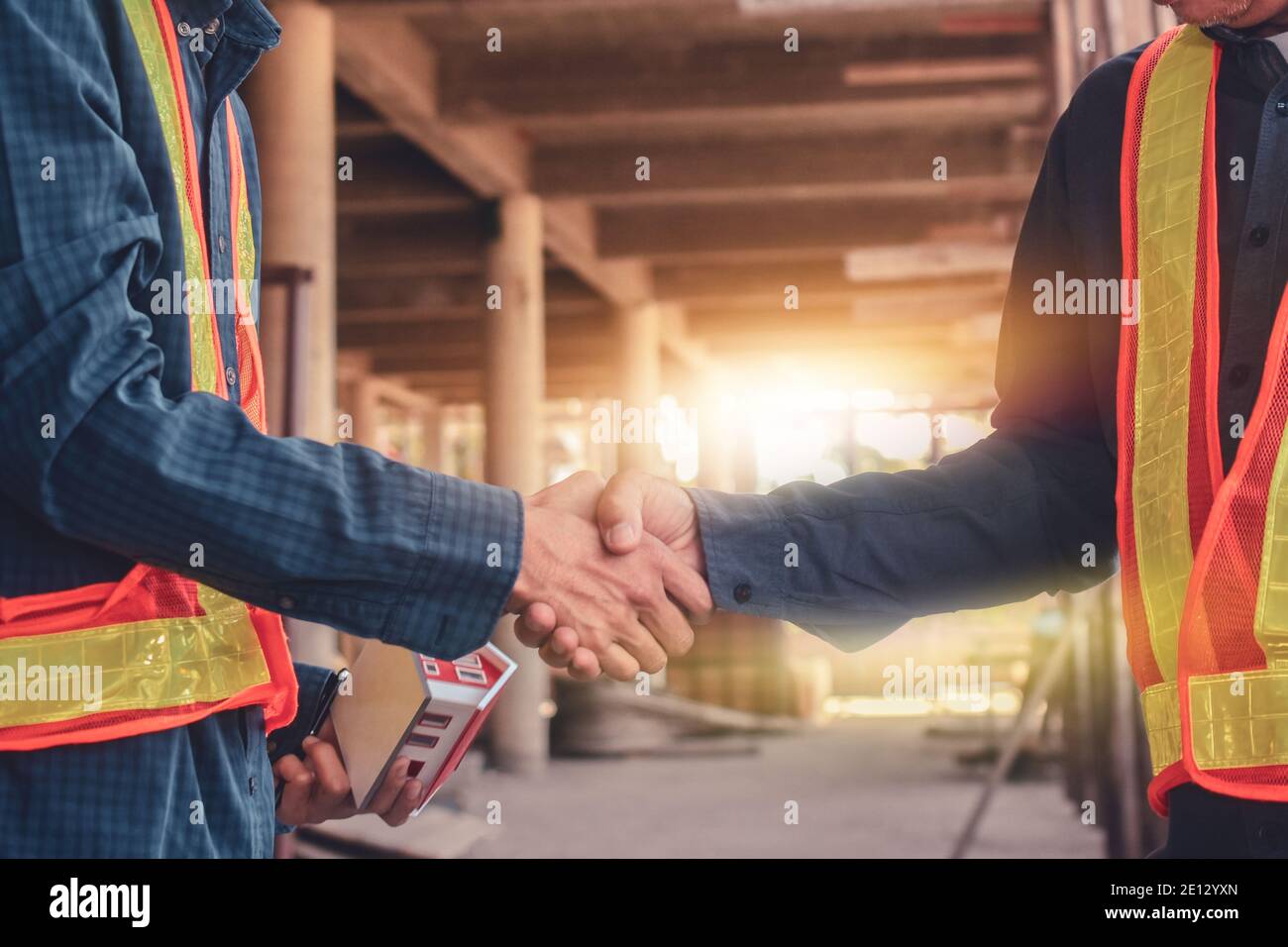 Two people engineer shake hand on site construction indoor Stock Photo ...