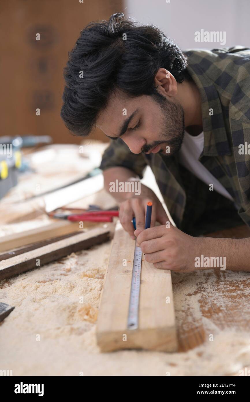 A CARPENTER DILIGENTLY MARKING MEASUREMENTS ON WOOD Stock Photo - Alamy
