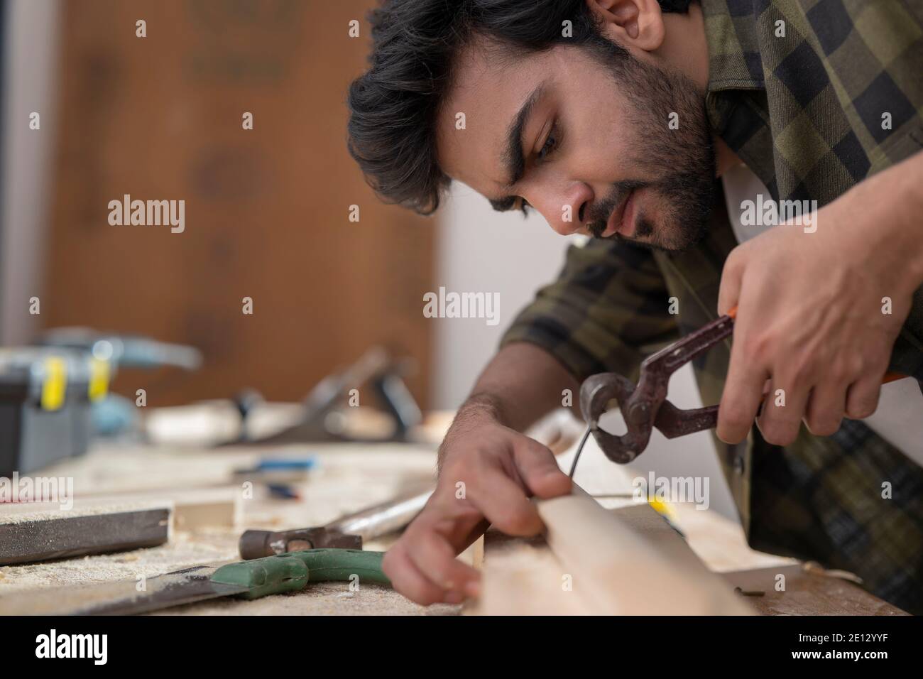 A CARPENTER USING PLYER TO PULL OFF NAIL FROM WOOD Stock Photo - Alamy