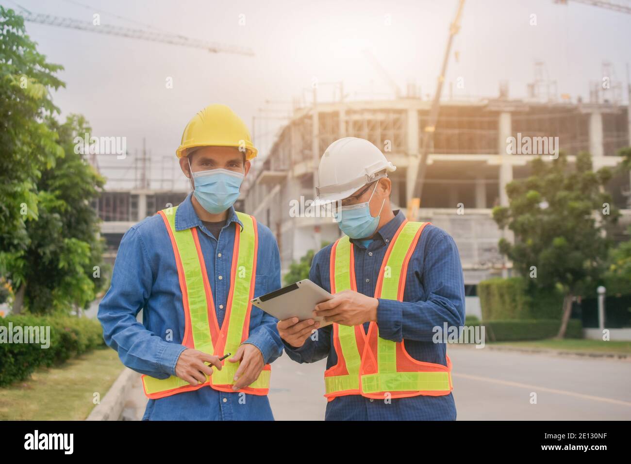 Two Engineer in face mask use tablet working building construction face ...