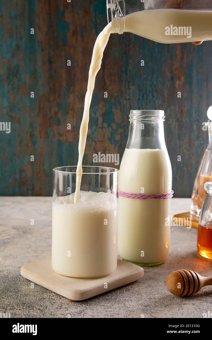 Milk being poured in a bottle lying next to a glass Stock Photo - Alamy