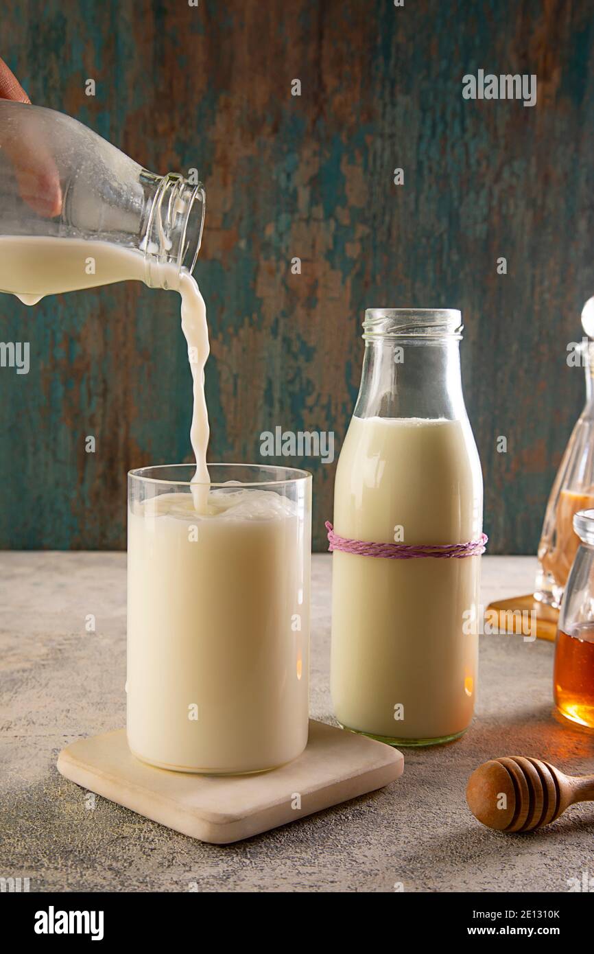 Milk being poured in a bottle lying next to a glass Stock Photo - Alamy